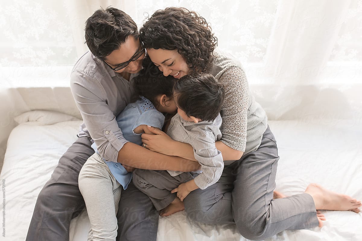  A Family Hugs On A Bed By Stocksy Contributor Alison Winterroth