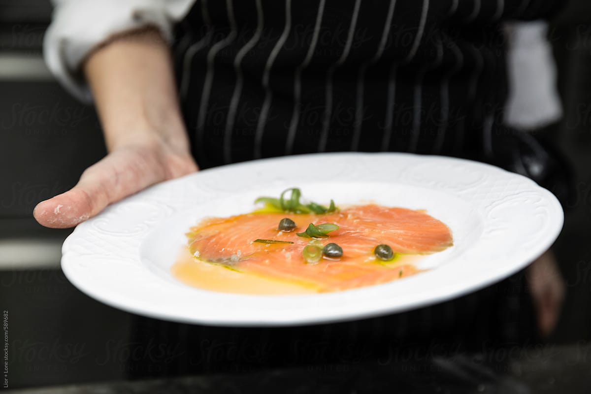 "Chef’s Hand Holding A Plate With Salmon Carpaccio" by Stocksy ...