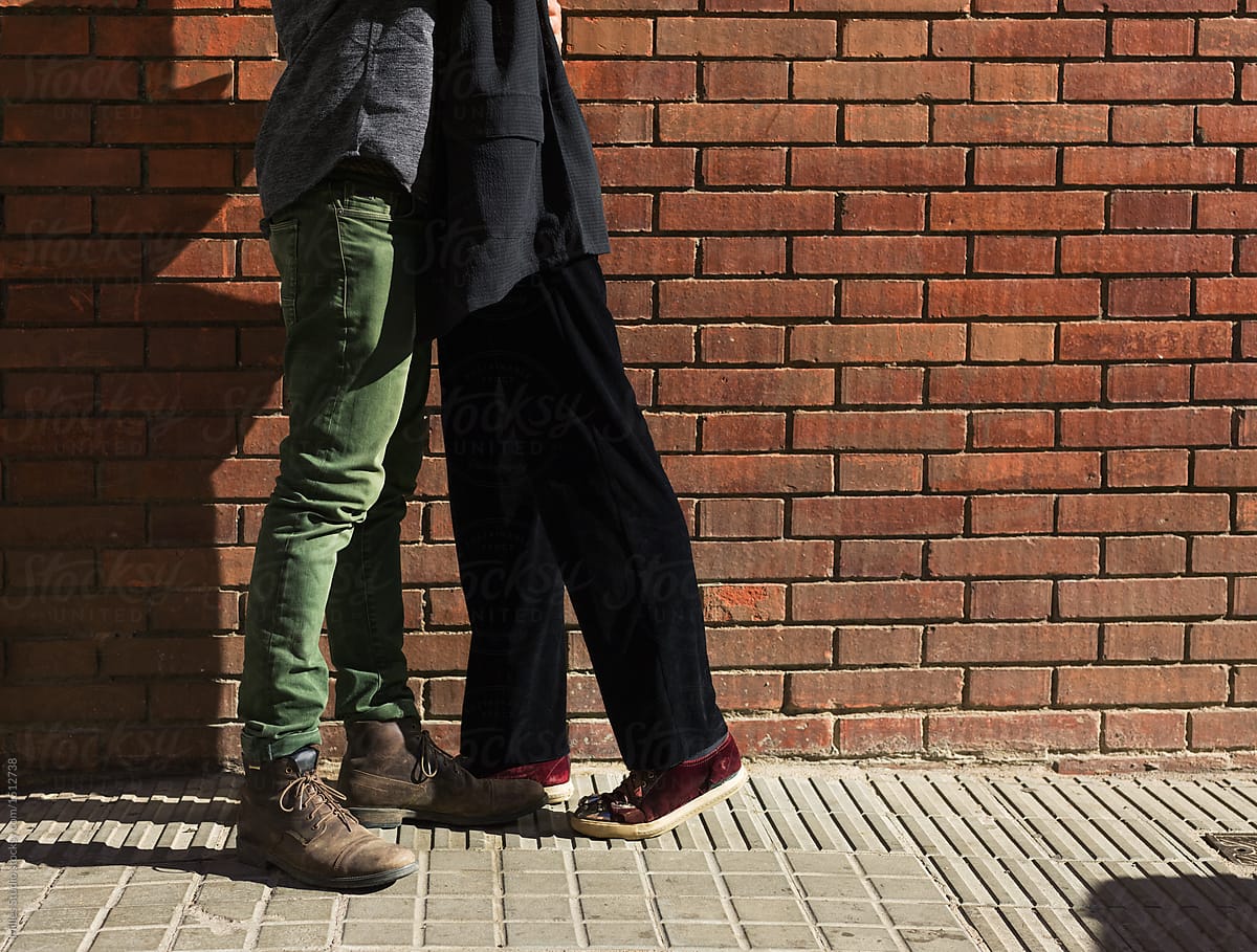 "Couple Cuddling On Street" by Stocksy Contributor "Milles Team" - Stocksy