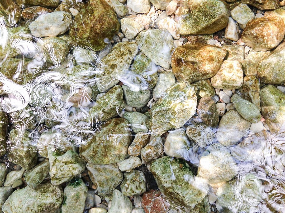"Pebbles In A Shallow Clear Water" by Stocksy Contributor "Mosuno ...