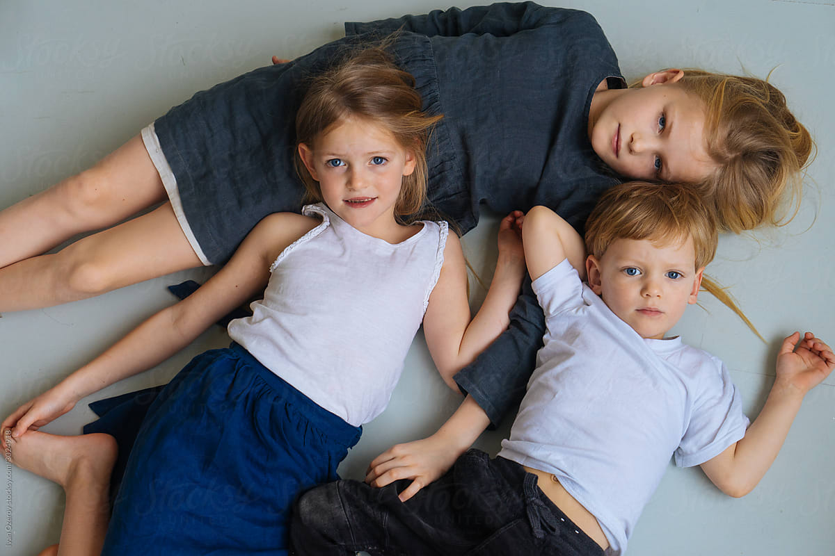 "Top View Of Three Charming Children Lying On The Floor" by Stocksy ...