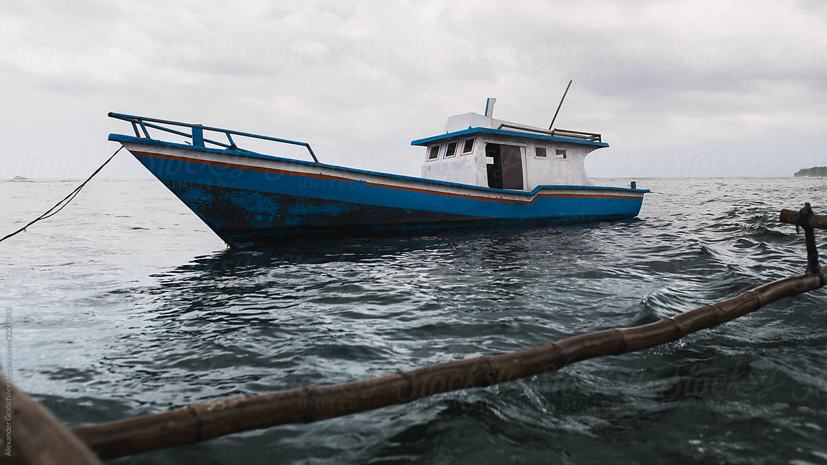 "Blue Fishing Boat On Calm Waters" by Stocksy Contributor "Eugenia ...