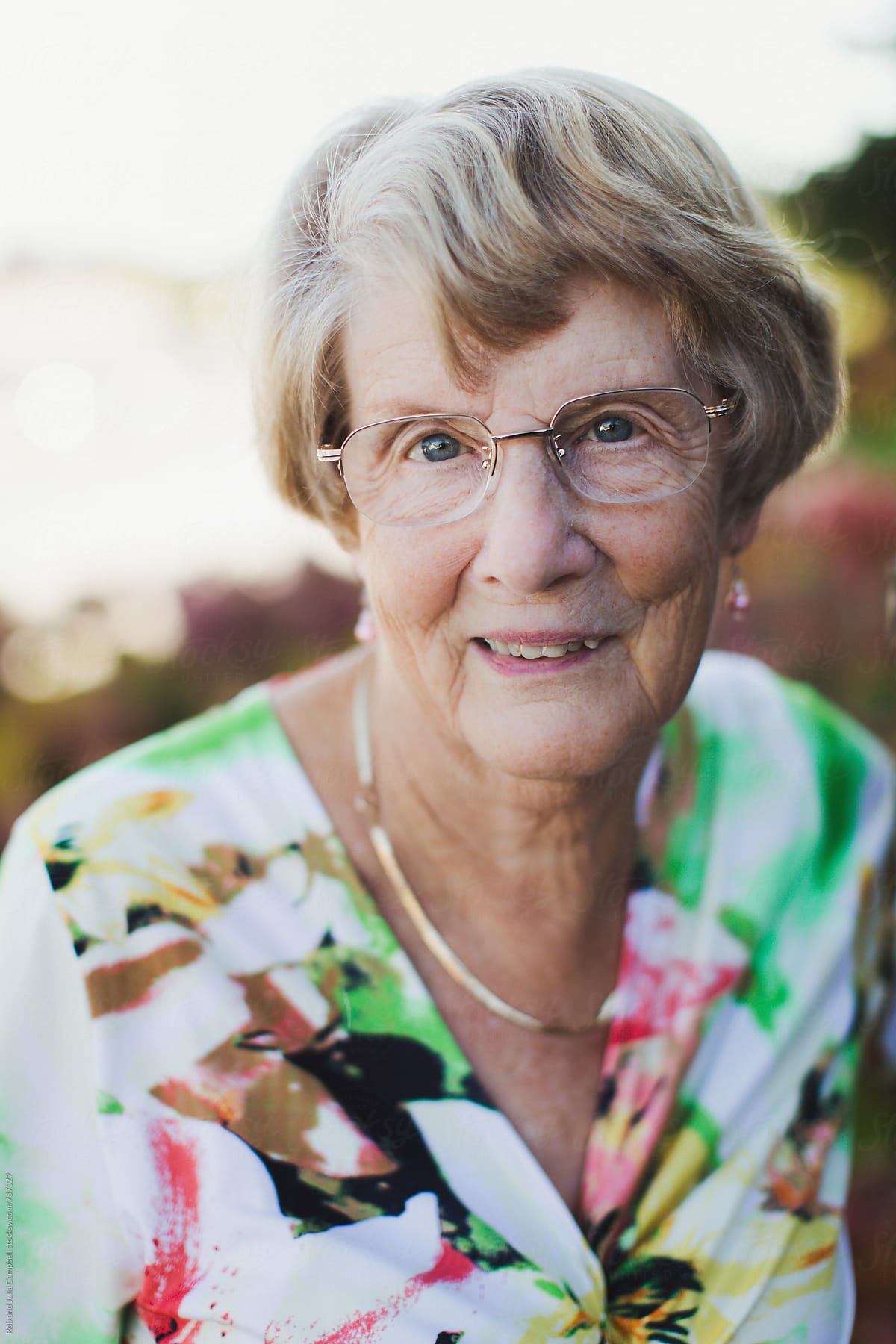 Happy Portrait Of Elderly Woman Outside Near Flowers By Stocksy Happy Portrait Of Elderly Woman Outside Near Flowers By Stocksy