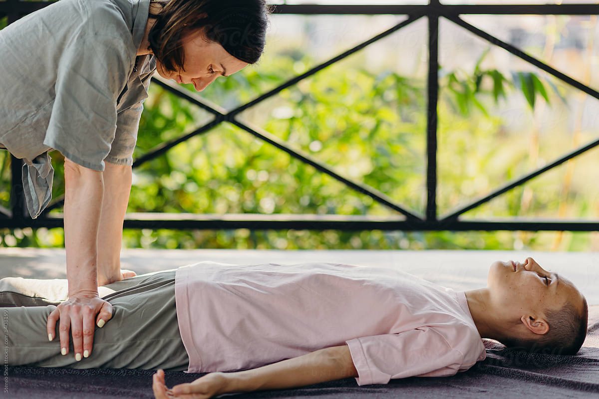 Calm woman pressing on legs of client during massage - Stock Image ...