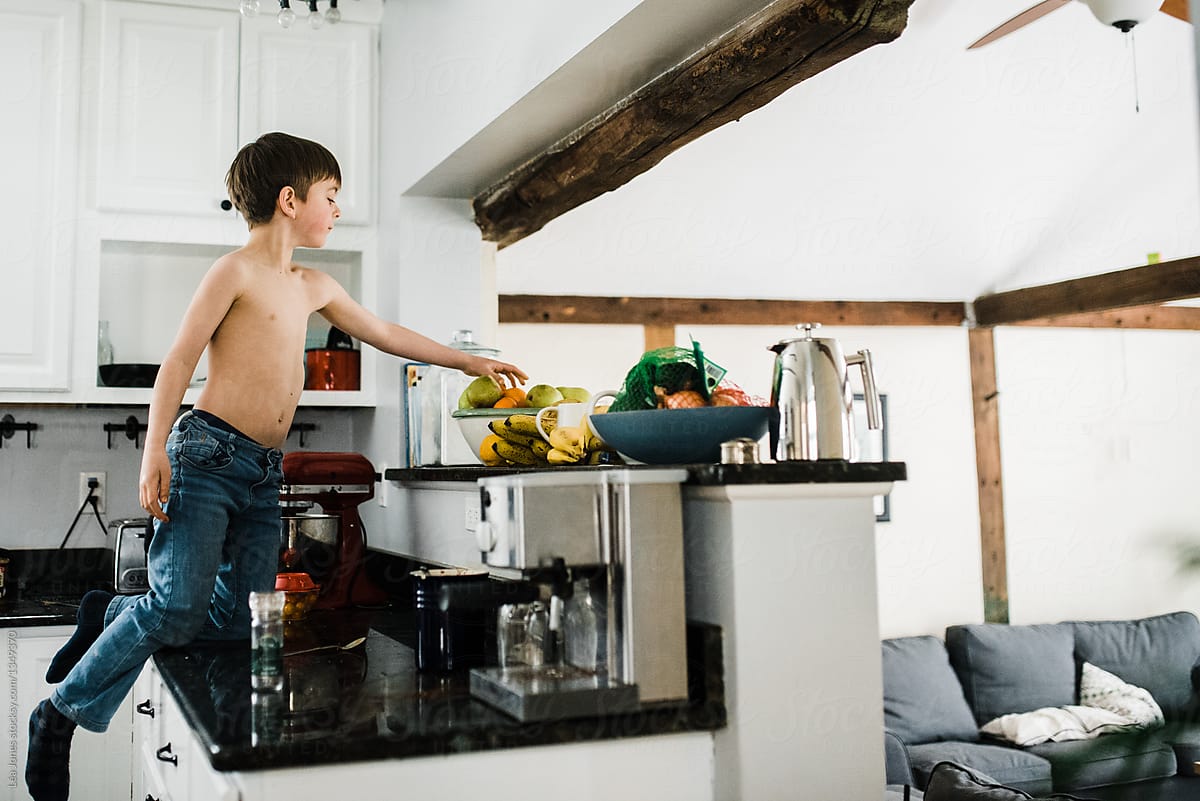 "Boy On Kitchen Counter Getting Some Fruit" by Stocksy Contributor "Lea ...