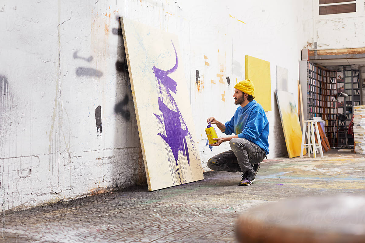 "Male Artist Painting On Canvas While Crouching In Studio" by Stocksy ...