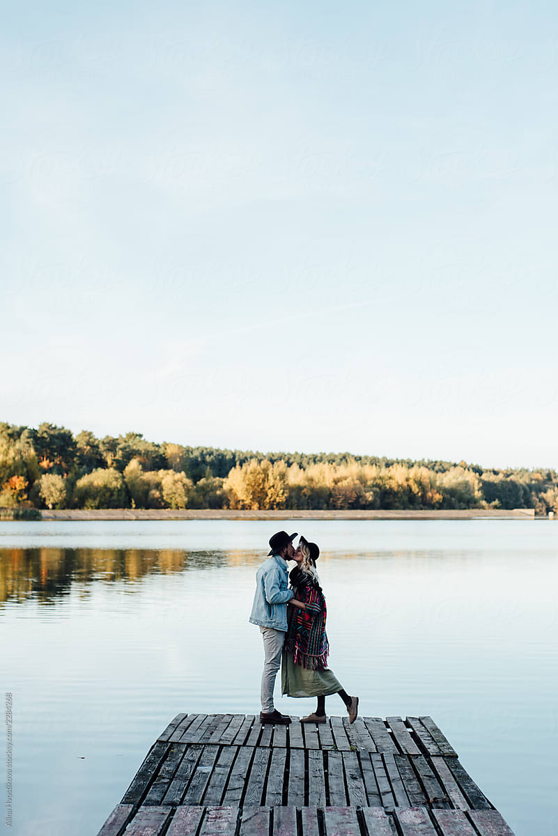 "Couple Kissing On Pier Of Beautiful Lake Near Dog" by Stocksy ...