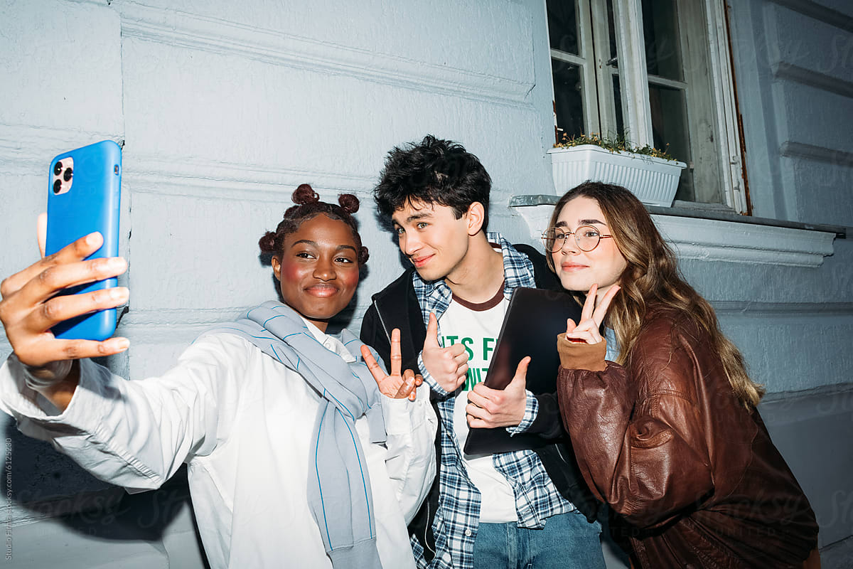 "Teens Taking Selfie Outside" by Stocksy Contributor "Studio Firma ...