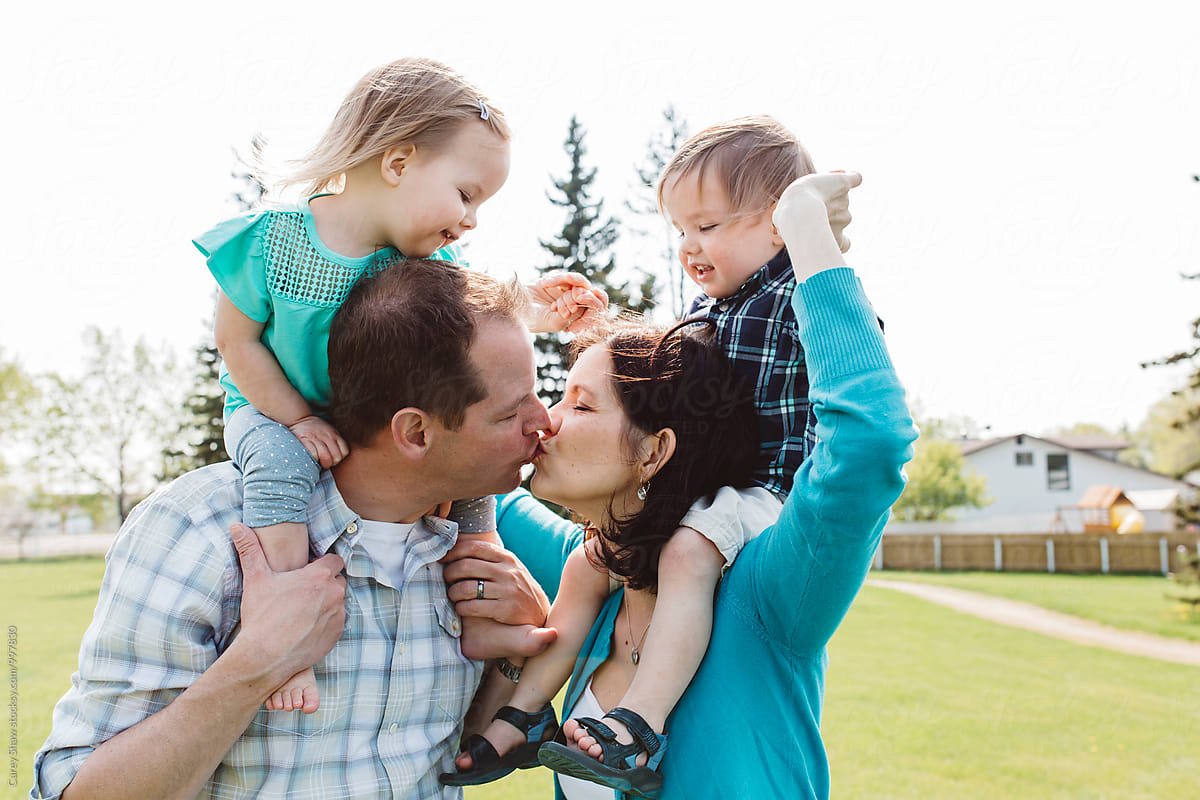 "Twin Siblings Sitting On Parents Shoulders" by Stocksy Contributor ...