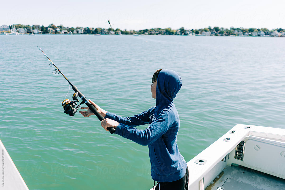 "Boy Fishing On A Boat" by Stocksy Contributor "Lea Jones" - Stocksy