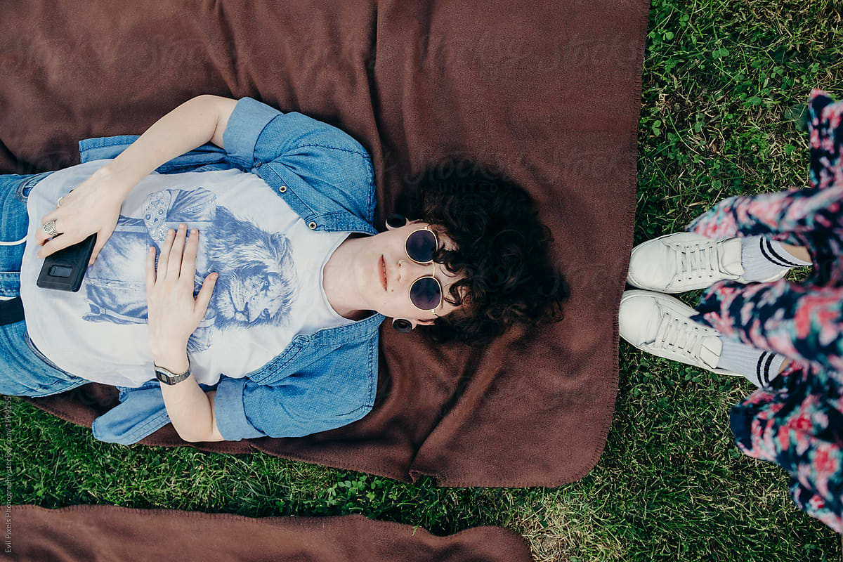 "Tomboy Lying On The Grass" by Stocksy Contributor "Studio KME" - Stocksy