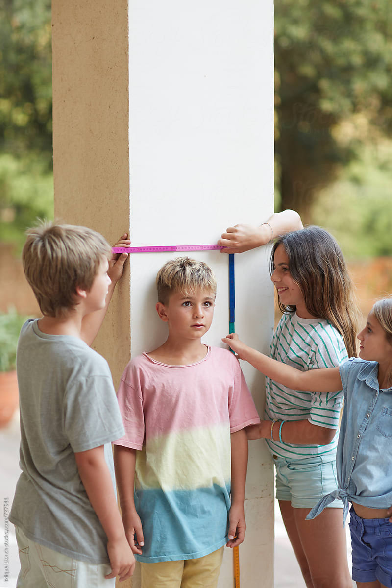 "Little Man Being Measured By Other Children In A Kid's Party" by ...