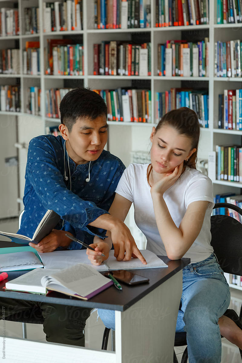 "Asian Guy Helping Classmate With Homework" by Stocksy Contributor ...
