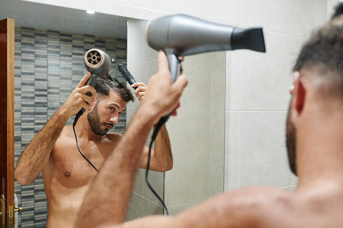 "Man Drying His Hair In A Bathroom Mirror" by Stocksy Contributor "Ivan ...