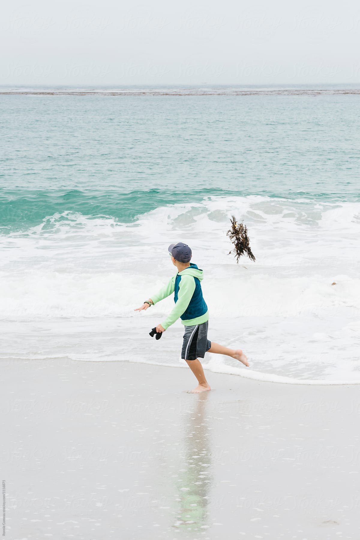 "Boy Throwing Seaweed Into The Ocean" by Stocksy Contributor "Ronnie ...