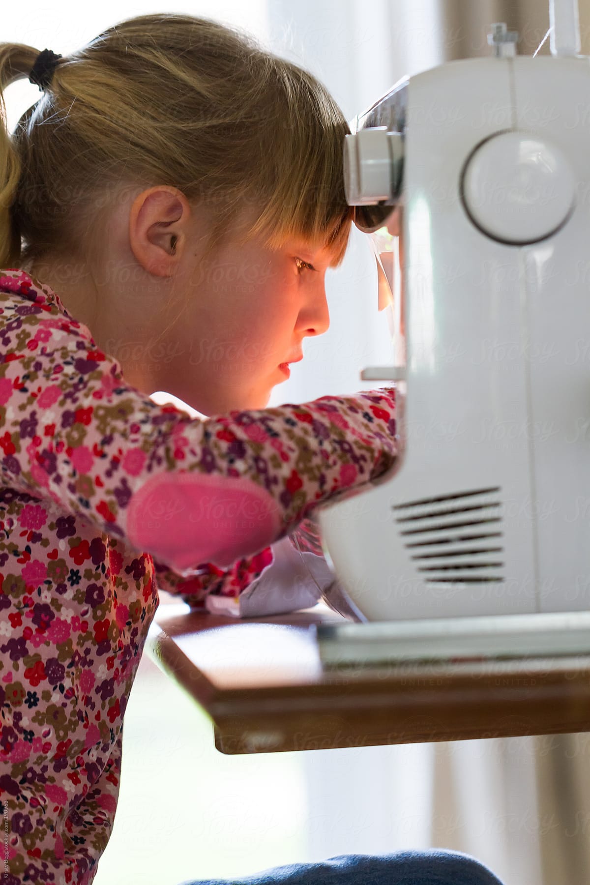 "Girl Sewing On Machine" by Stocksy Contributor "Kirsty Begg" - Stocksy