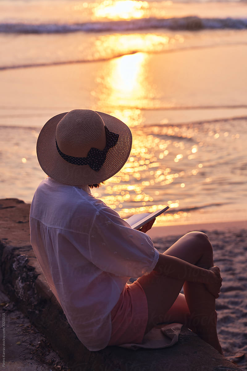 Peaceful faceless woman admiring sunset at seashore - Stock Image ...