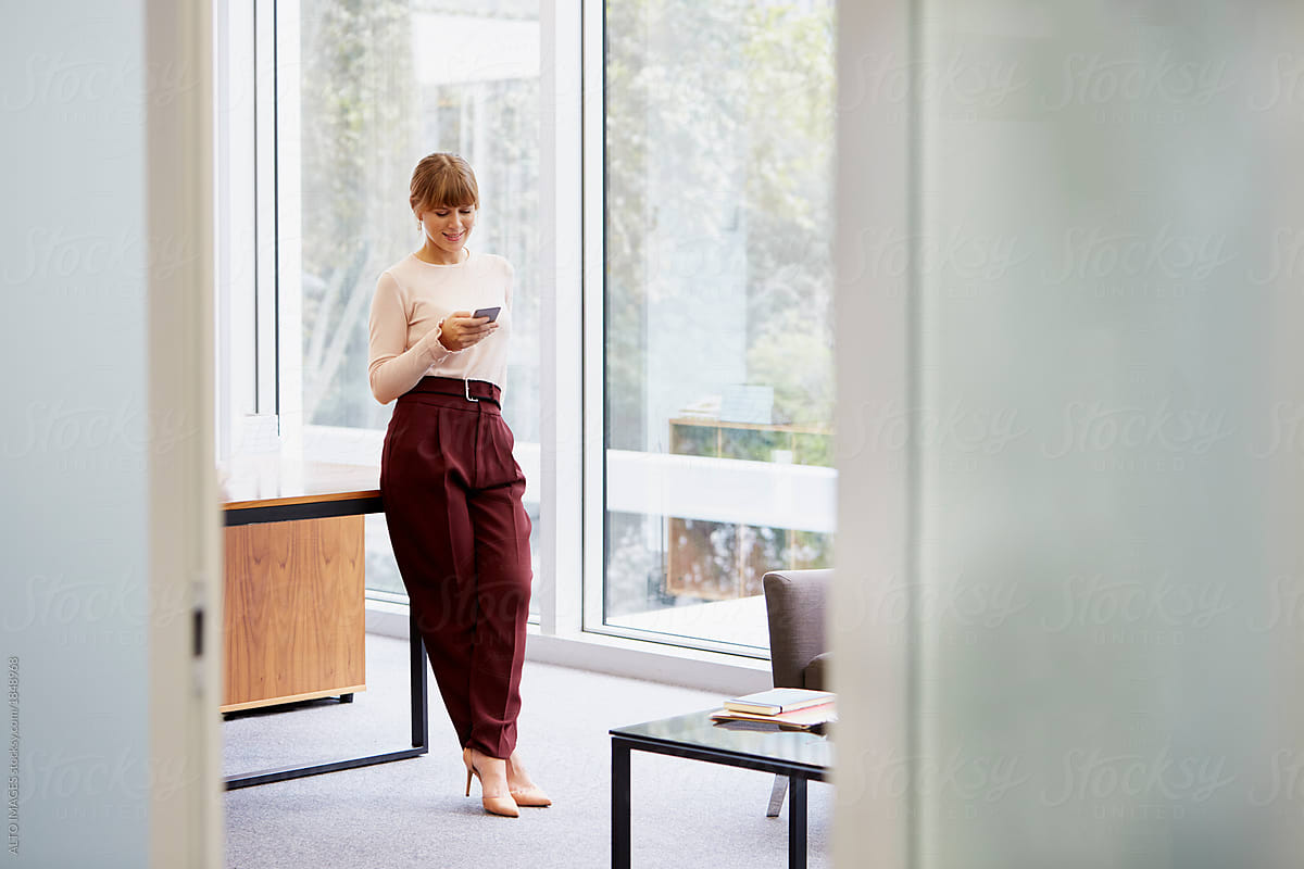 "Businesswoman Using Mobile Phone At Office" by Stocksy Contributor ...