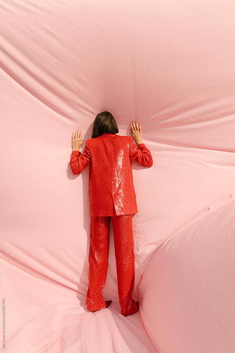 "Woman Wearing Red Shiny Suit Playing With A Huge Fabric" by Stocksy ...