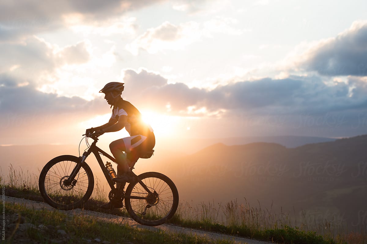 Man Riding A Bike Uphill Against Sunset Sky By RG B Images Uphill Man Riding A Bike Uphill Against Sunset Sky By RG B Images Uphill