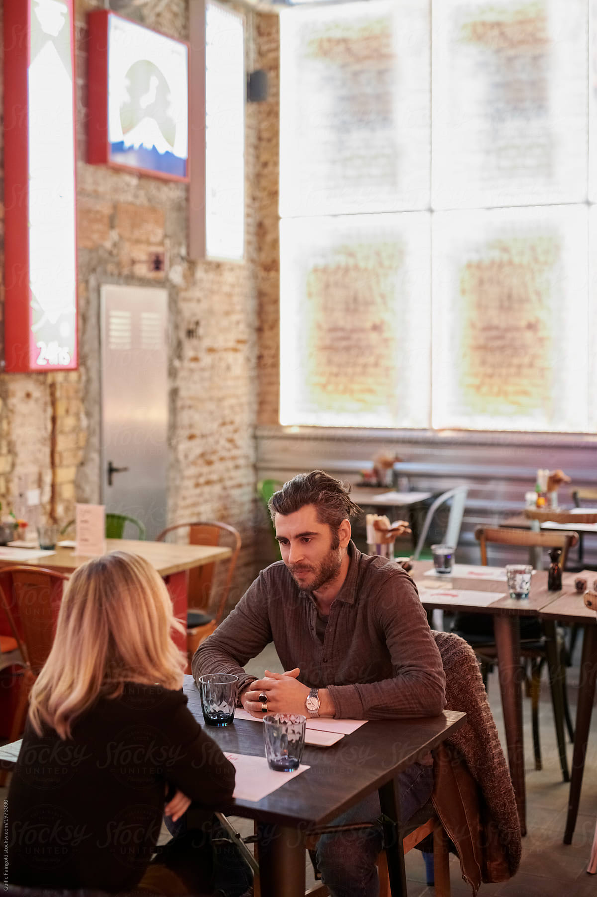 "Couple Sitting In Restaurant." by Stocksy Contributor "Guille Faingold ...