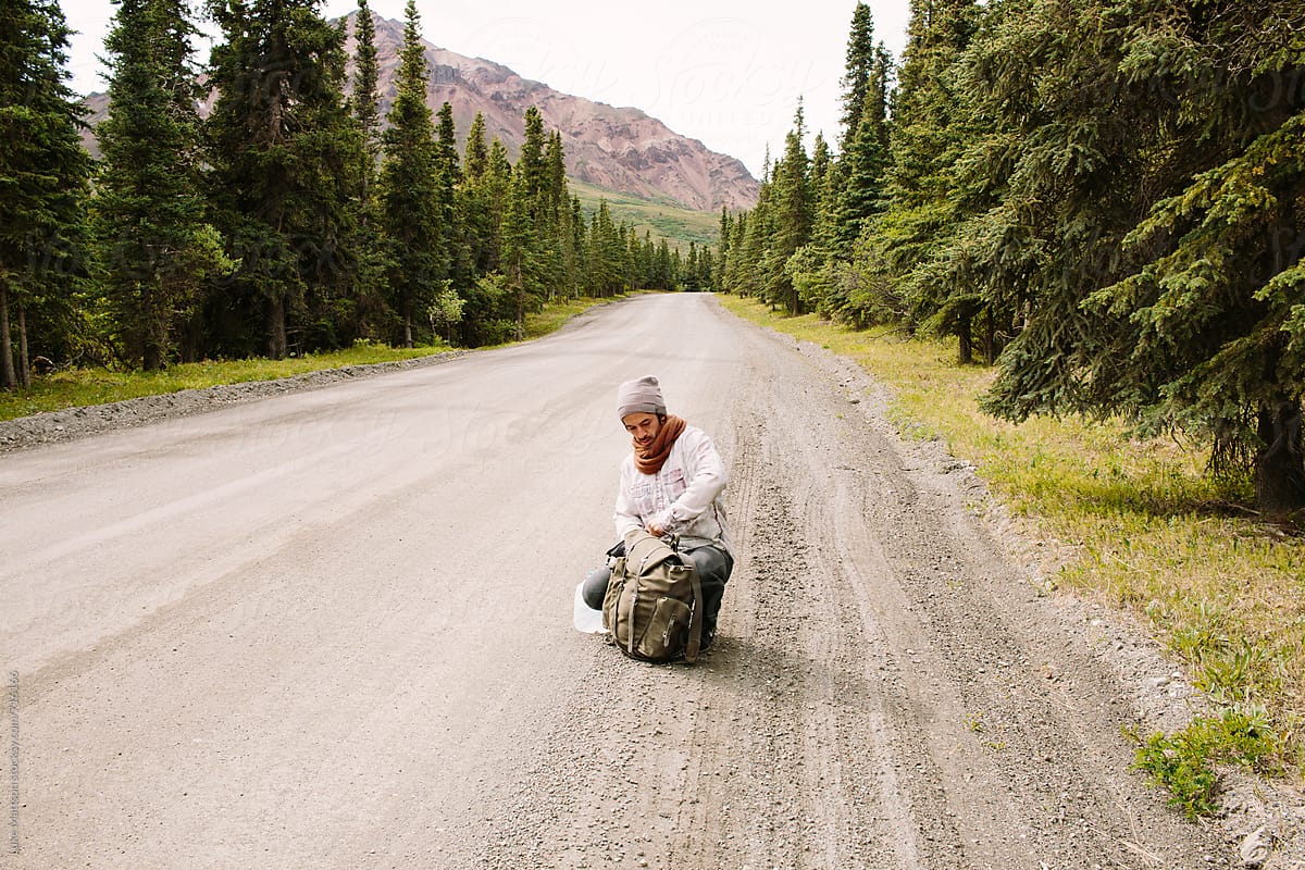 "Young Man Rummaging Through His Backpack On A Gravel Road In Denali ...