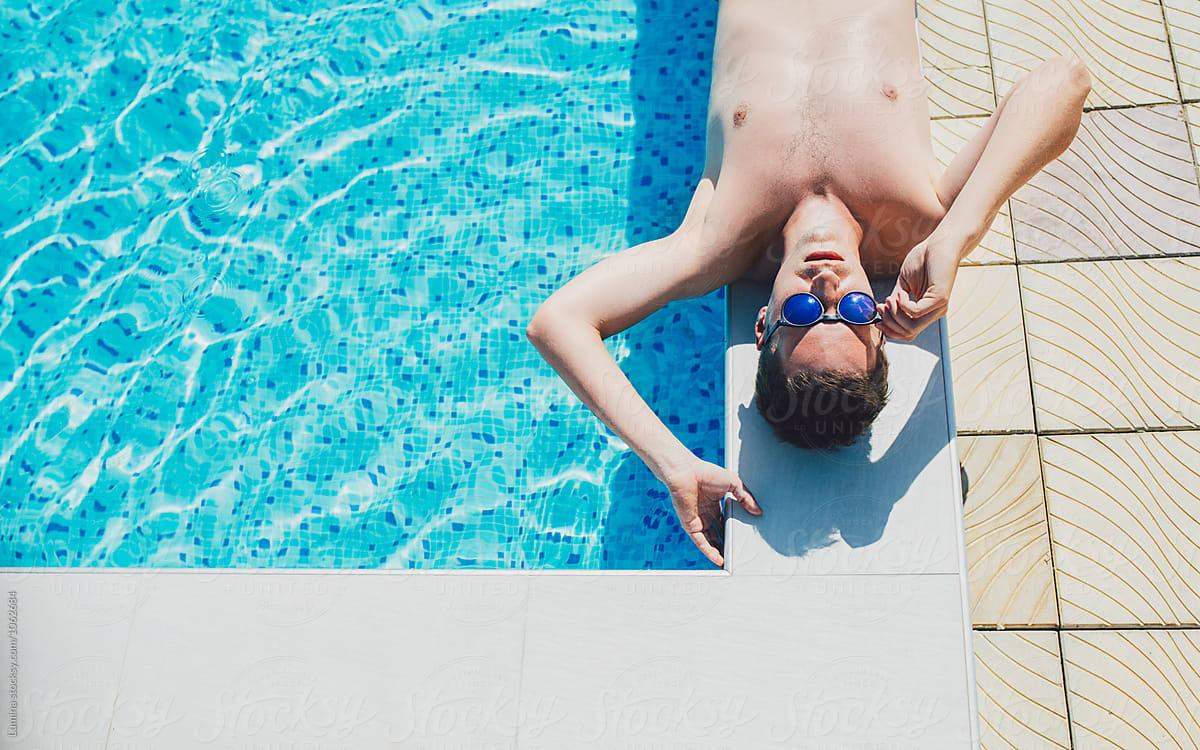 "Man Lying On Edge Of The Swimming Pool" by Stocksy Contributor "Lumina ...