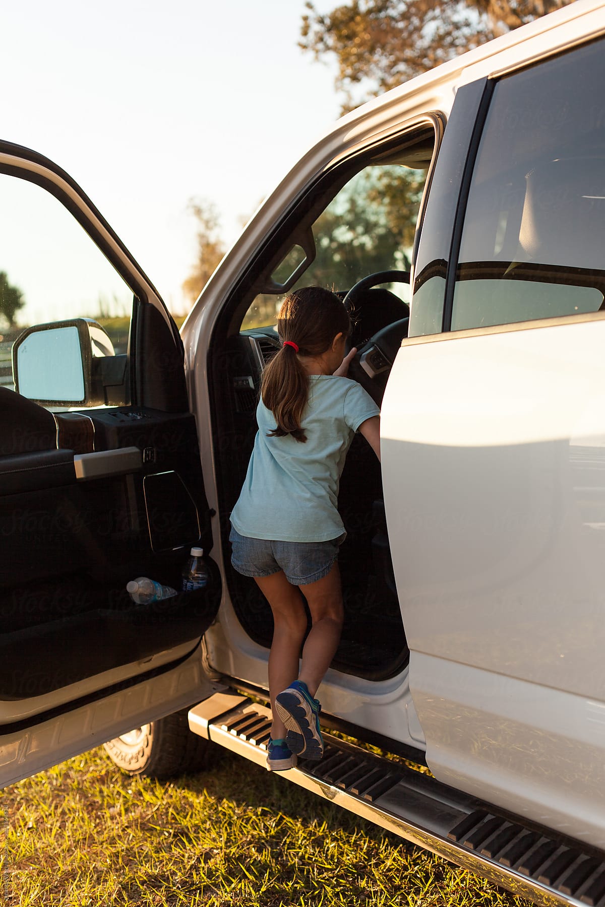 "Young Girl Climbing Into The Driver Seat Of A Pick Up Truck" by ...