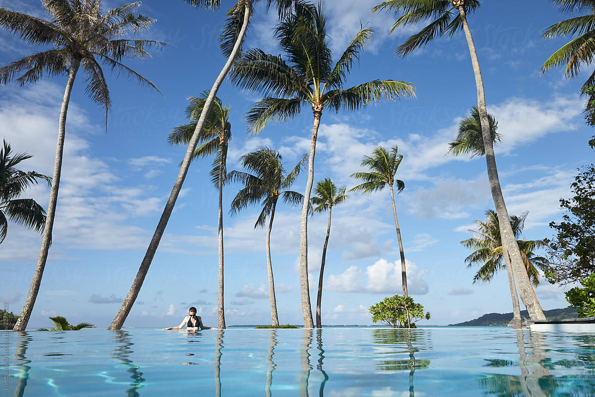 "Woman Relaxing In Infinity Pool On Tropical Vacation" by Stocksy ...