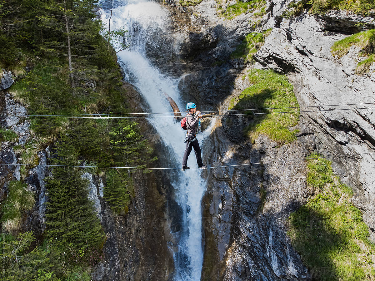 "Climber Crossing Wire Suspension Bridge" by Stocksy Contributor "Alina ...