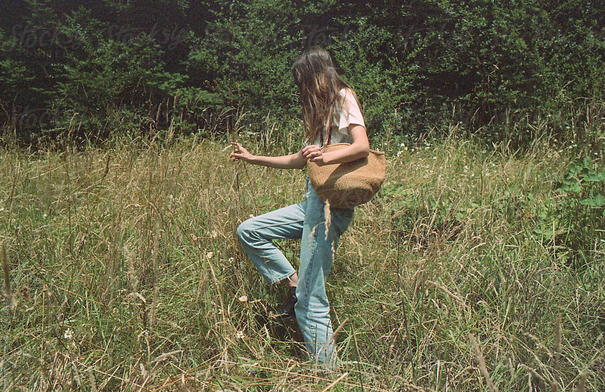 "Young Woman Frolicking In A Field In Jeans With A Bag" by Stocksy ...