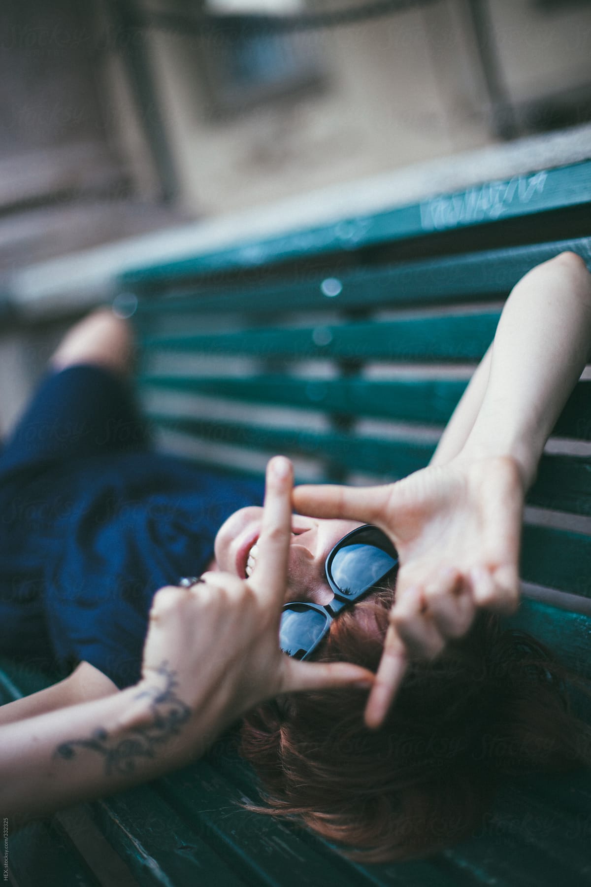 "Smiling Woman Lying On A Bench" by Stocksy Contributor "Mattia" - Stocksy