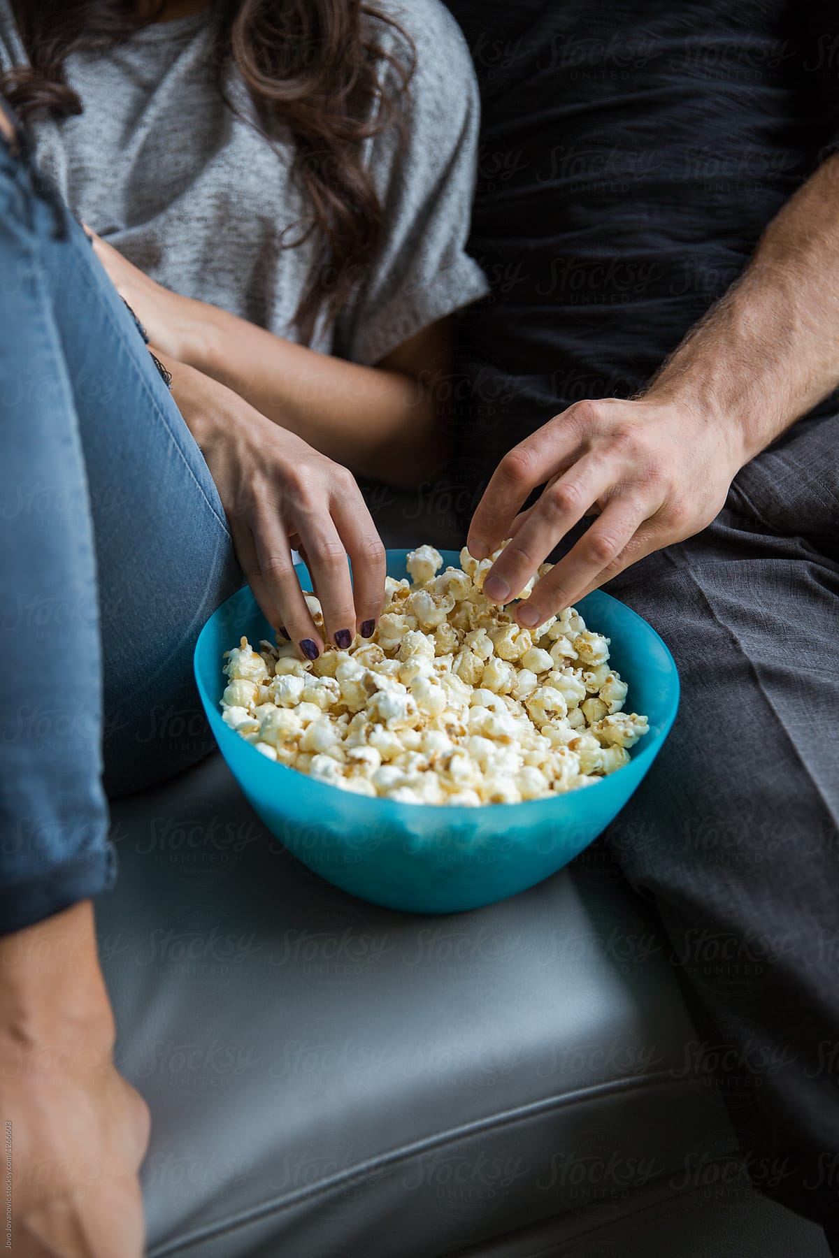 "Couple Eating Popcorn On Couch Together" by Stocksy Contributor "Jovo ...