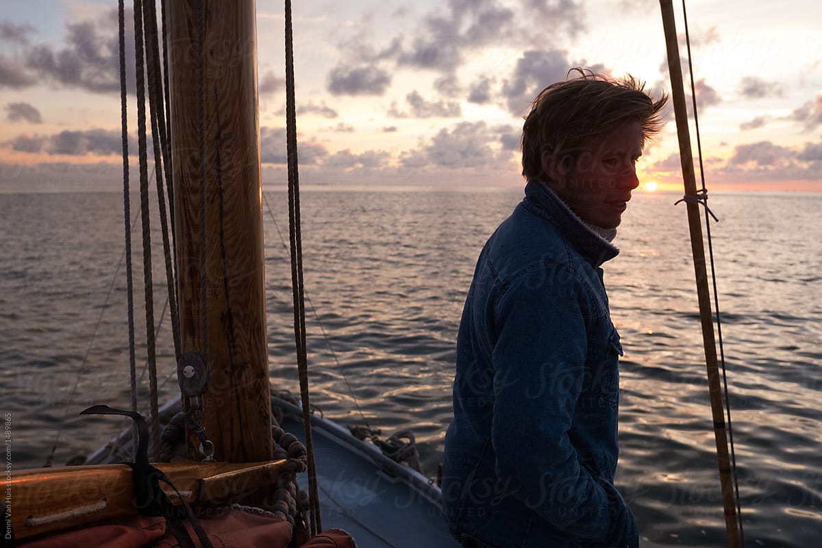 "Man On Deck Of A Sailboat At Sunset." by Stocksy Contributor "Denni ...