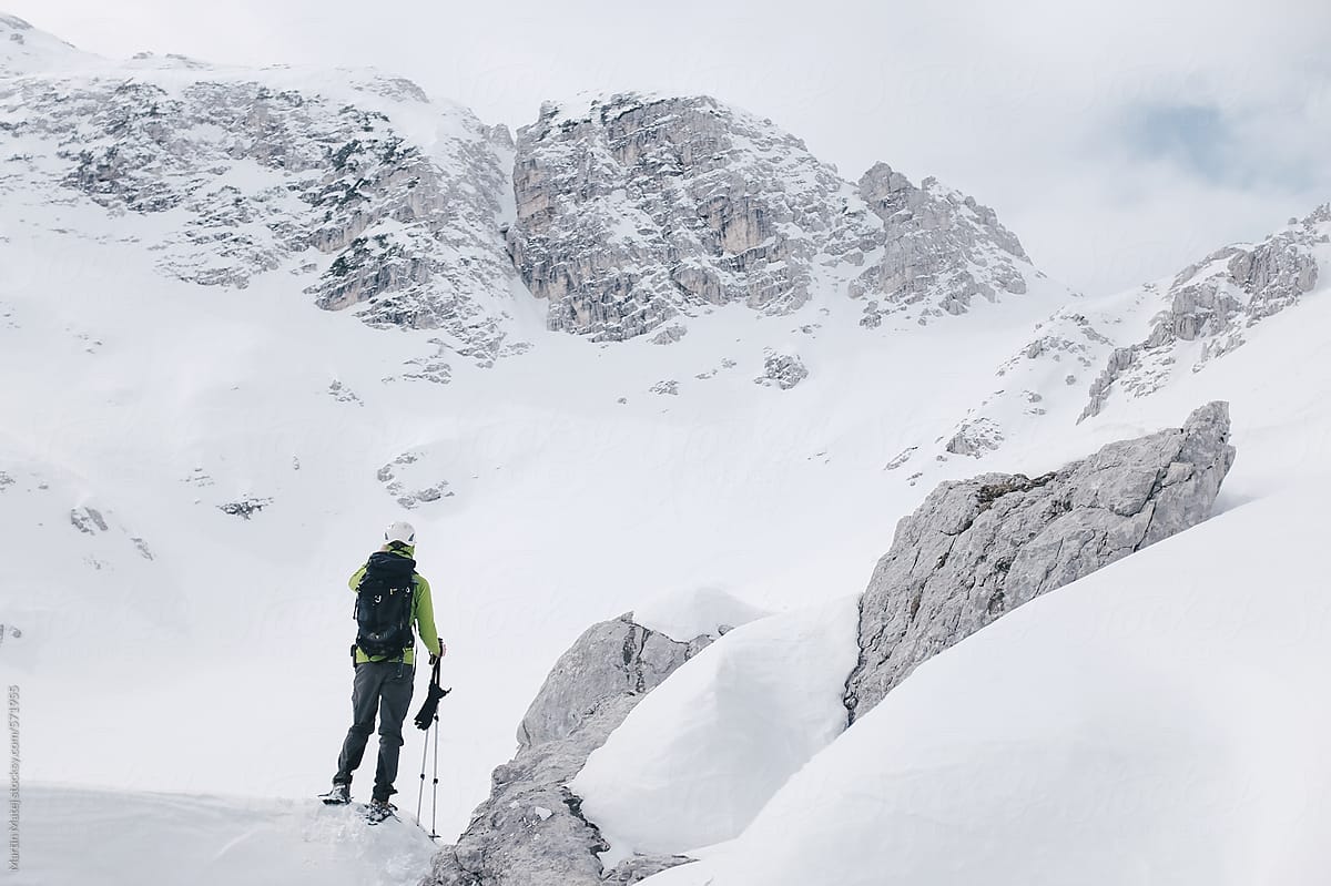 "Man Standing By Rocks Admiring Snowy Mountains" by Stocksy Contributor ...