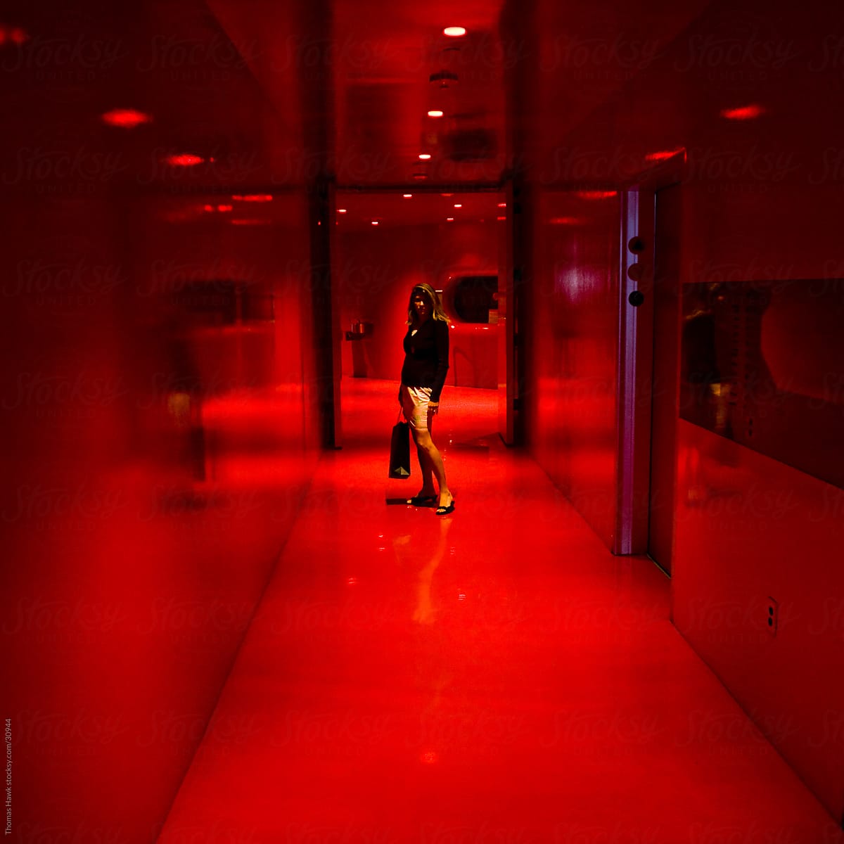 "Woman In Red Room" by Stocksy Contributor "Thomas Hawk" - Stocksy