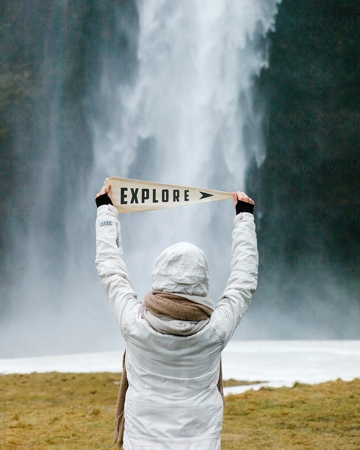 "Back View Of Woman Holding Banner Near Waterfall In Iceland" by ...