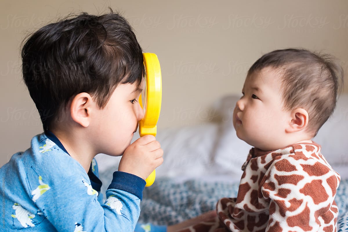 "Brother Looking At Baby With Magnifying Glass" by Stocksy Contributor ...