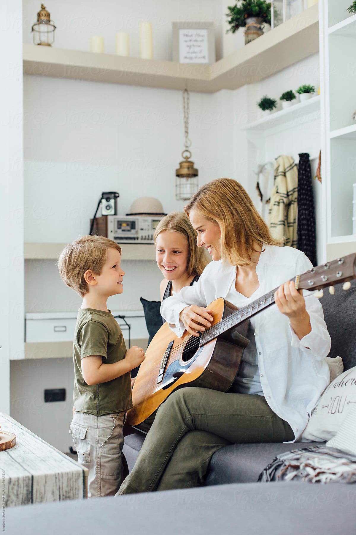 "Mother Plays Guitar Among Her Kids" by Stocksy Contributor "Marko ...