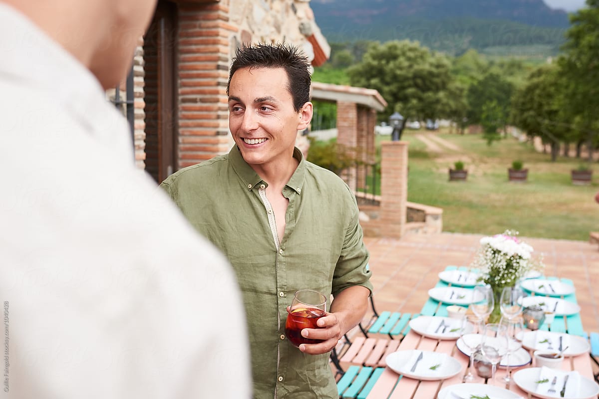 "Smiling Man With Drink" by Stocksy Contributor "Guille Faingold" - Stocksy