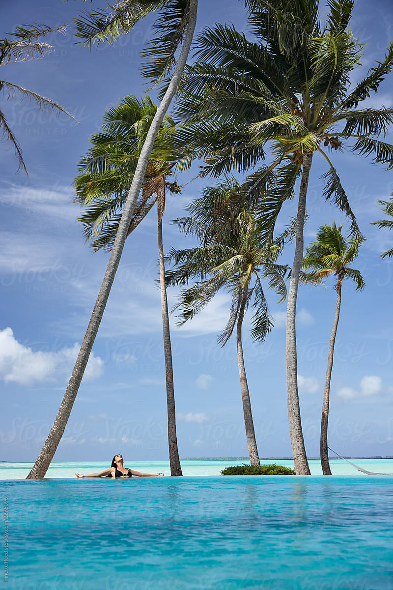 "Woman Relaxing In Infinity Pool On Tropical Vacation" by Stocksy ...