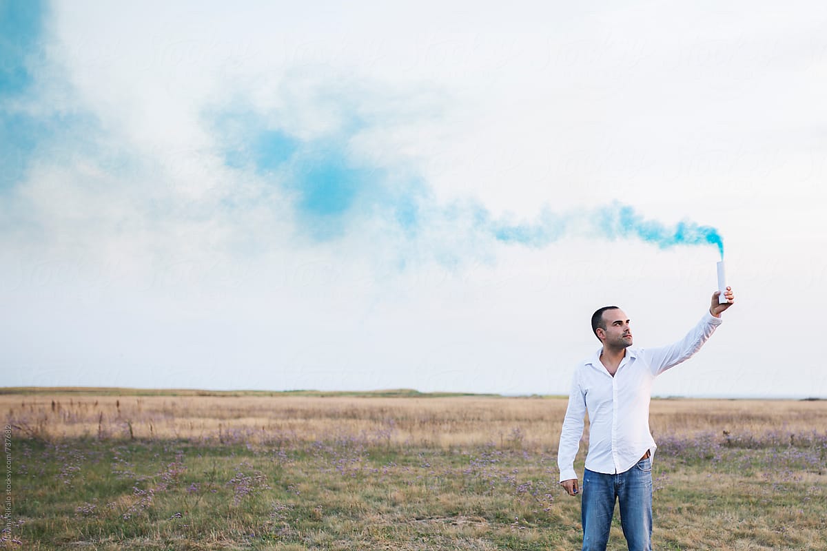 "Man Holding Smoke Bomb In Nature" by Stocksy Contributor "Jovana ...