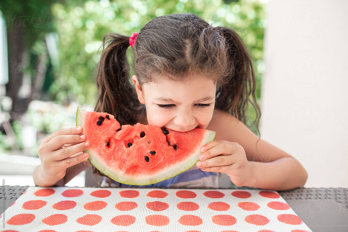 "Young Girl Biting Into A Slice Of Watermelon" by Stocksy Contributor ...