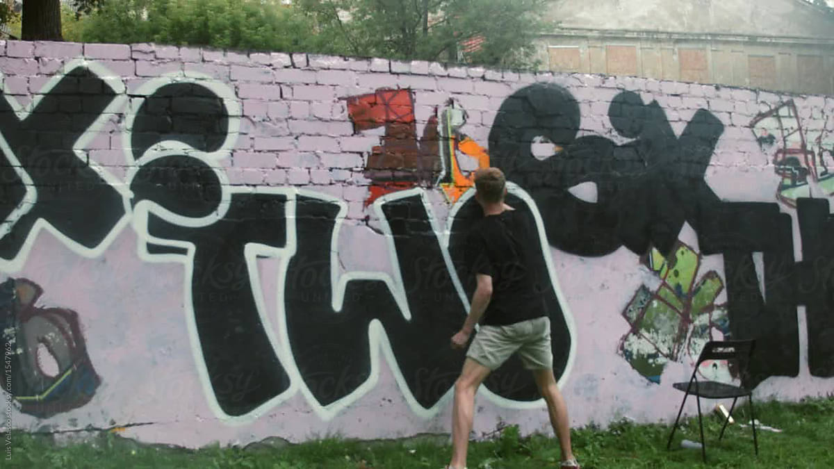 "Young Boy Street Artist Making A New Graffiti With A Spray On A Wall ...