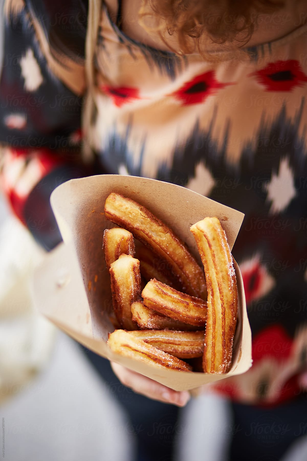 "Woman Holding Churros With Sugar" by Stocksy Contributor "Martí Sans ...