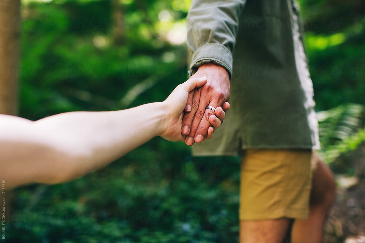 "Detail Of Young Hiker Couple Holding Hands In The Forest." by Stocksy ...