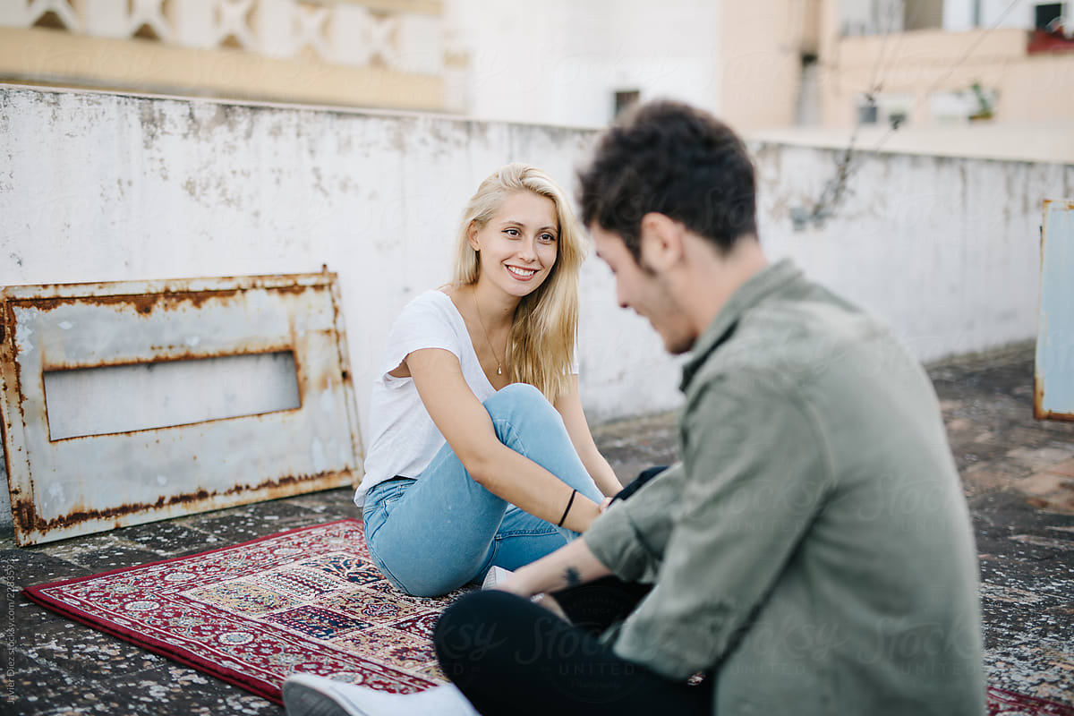 "Couple Speaking On Terrace" by Stocksy Contributor "Javier Díez" - Stocksy