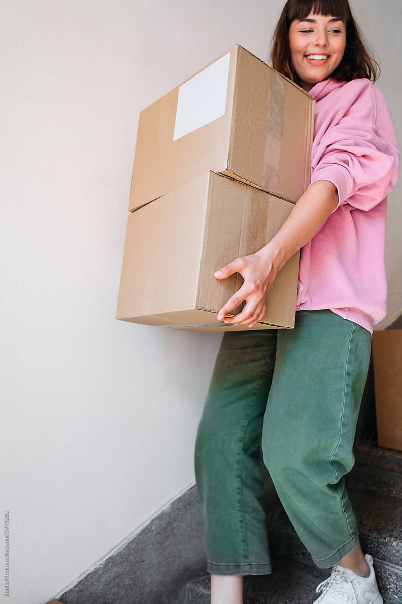 "Woman Carrying Boxes" by Stocksy Contributor "Studio Firma" - Stocksy