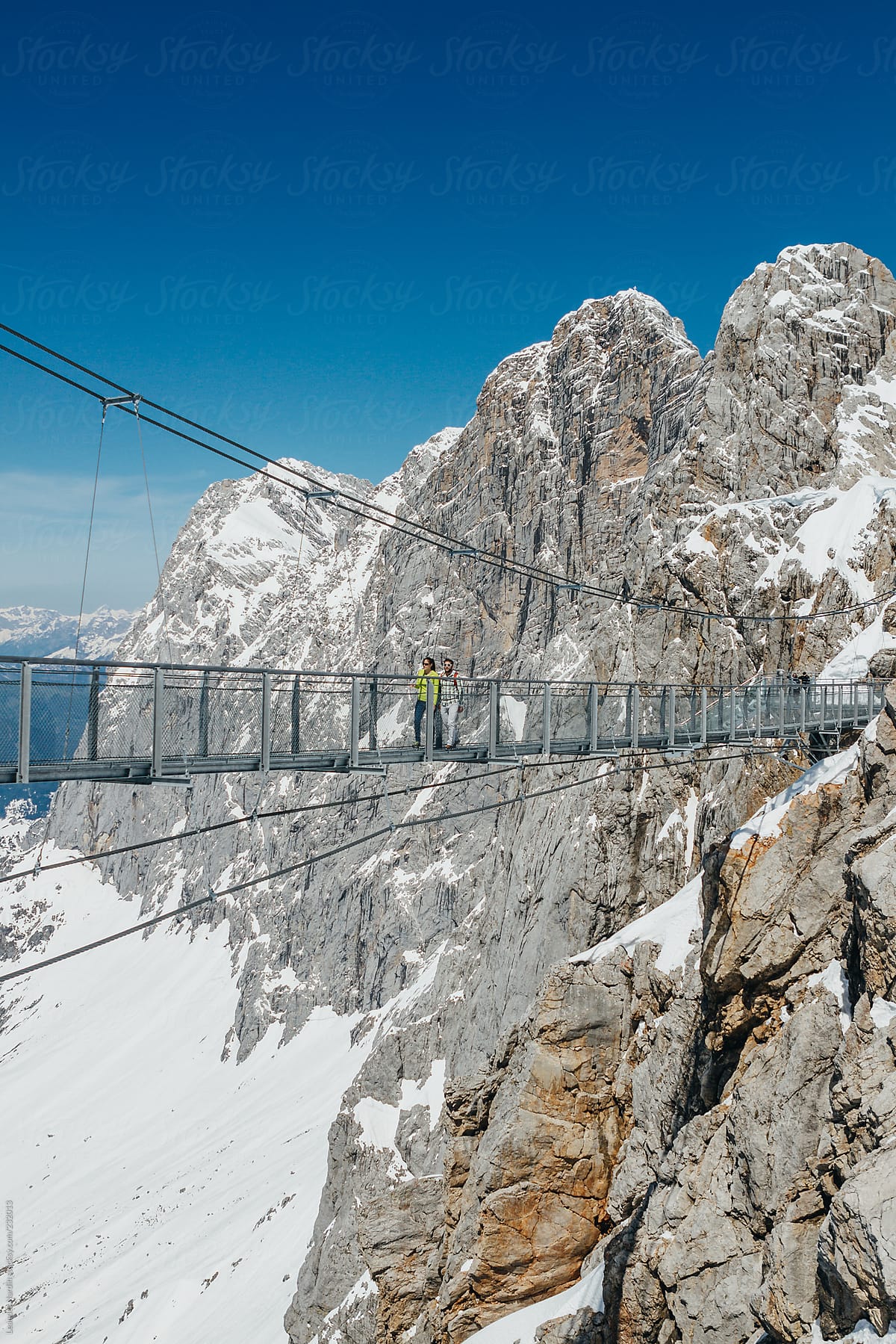 "Young Casual Couple Walking Along A Hanging Bridge In The Austrian ...