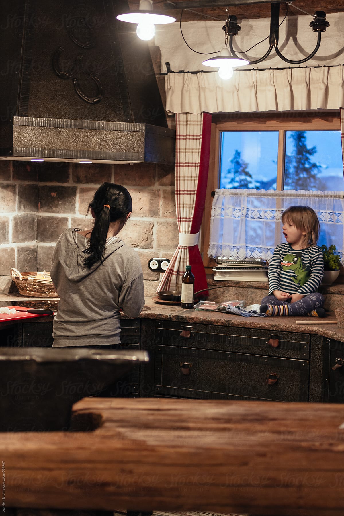 "Mother Cooking In Cast Iron Kitchen While Son Is Watching" by Stocksy ...